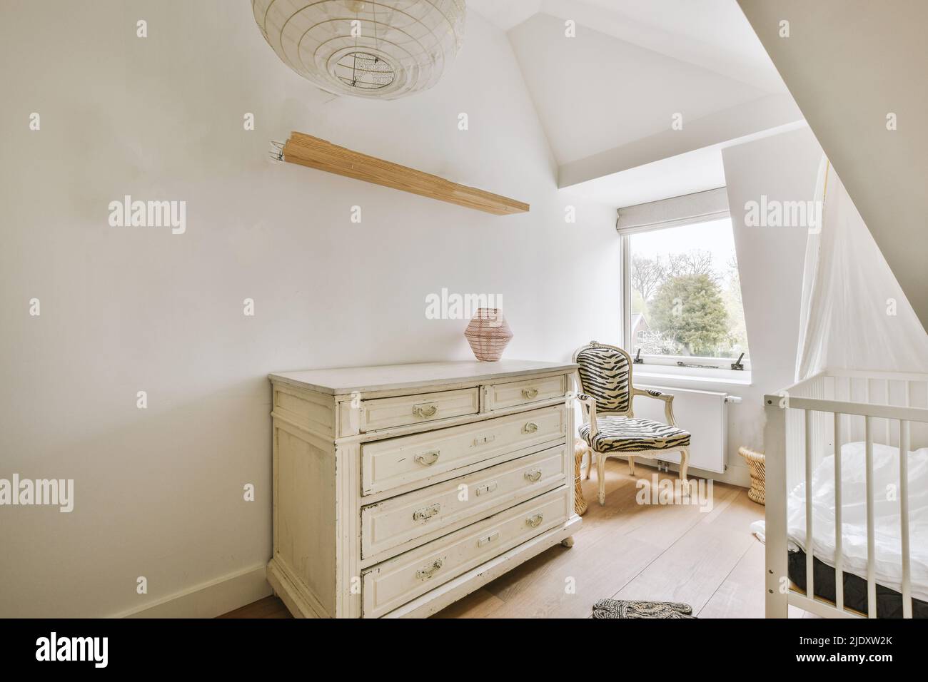Interior of a modern children's bedroom with a chest of drawers, a crib ...