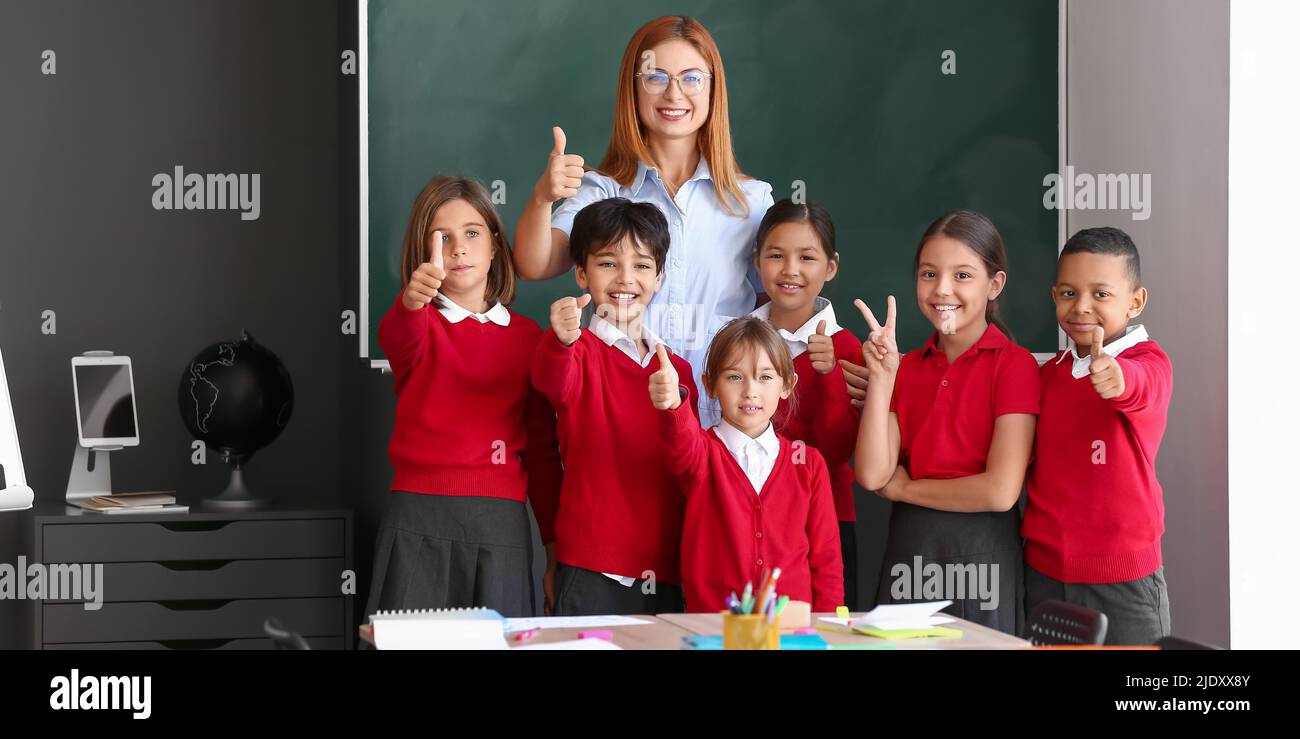 Group of children with teacher in classroom Stock Photo - Alamy