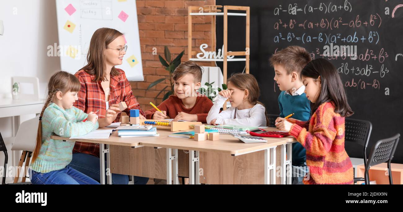 Children with math teacher during lesson in classroom Stock Photo - Alamy
