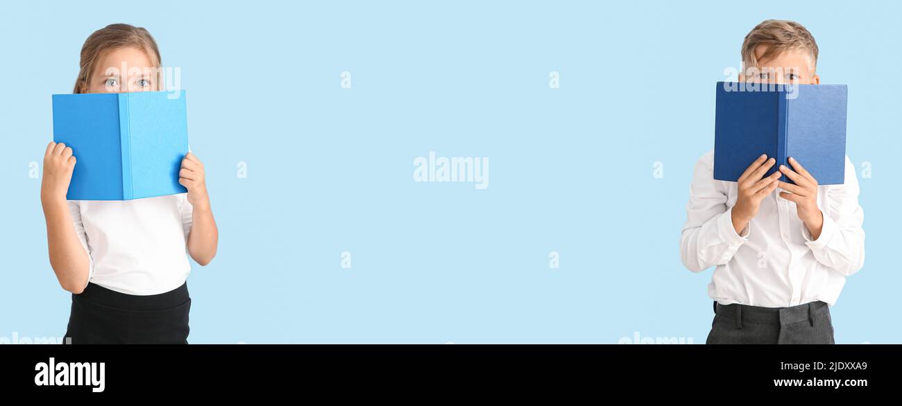 Cute little schoolchildren with books on light blue background with ...