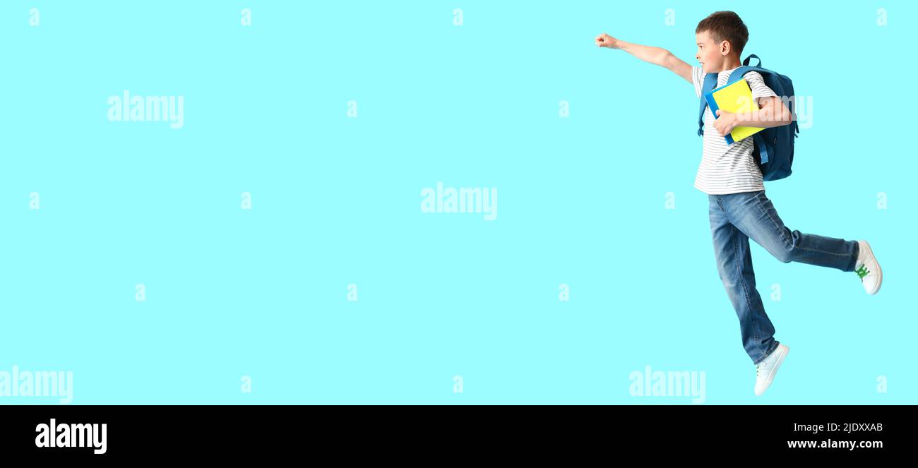 Little jumping schoolboy on light blue background with space for text ...