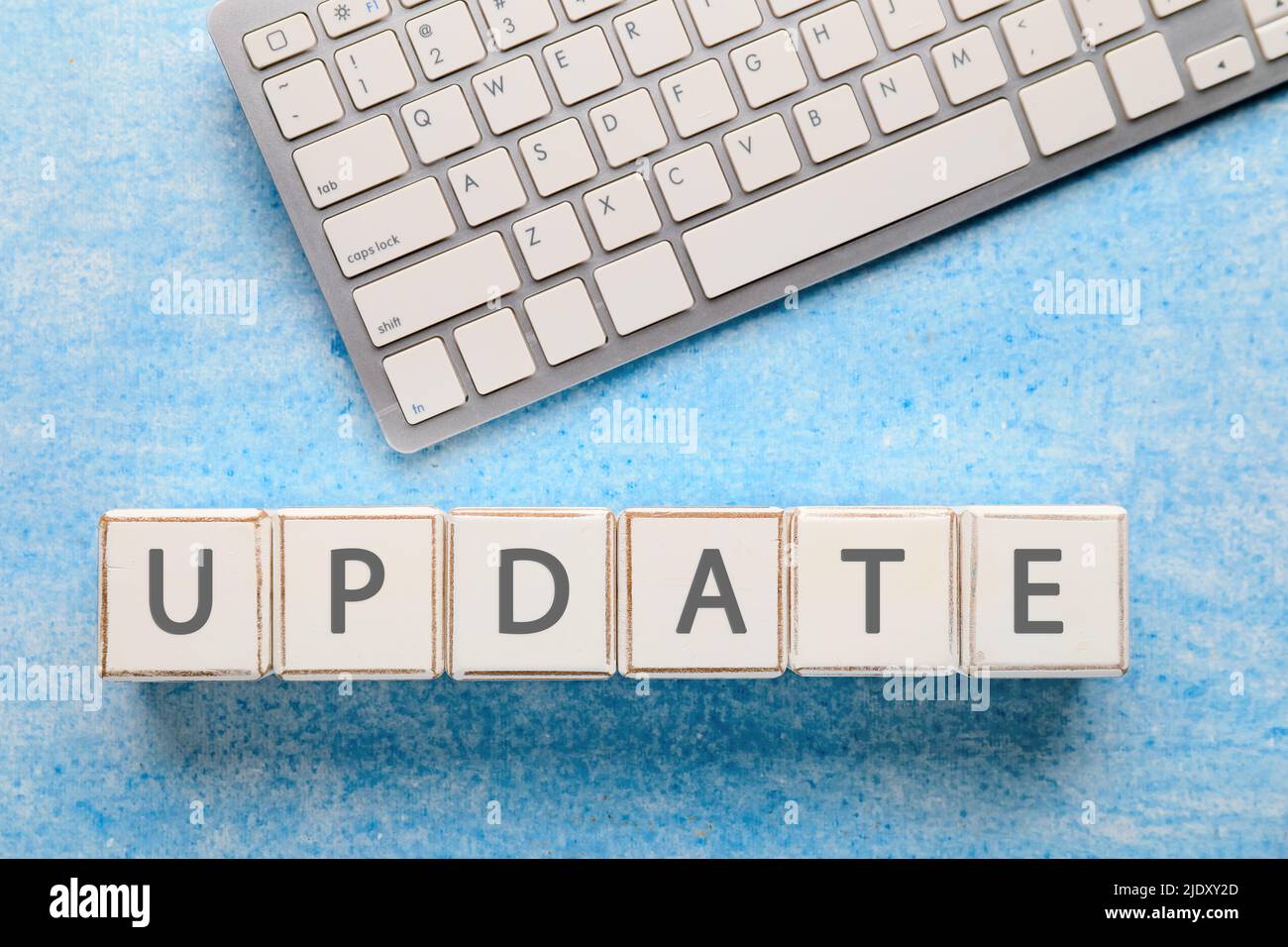 Word UPDATE made of cubes and PC keyboard on light blue background ...