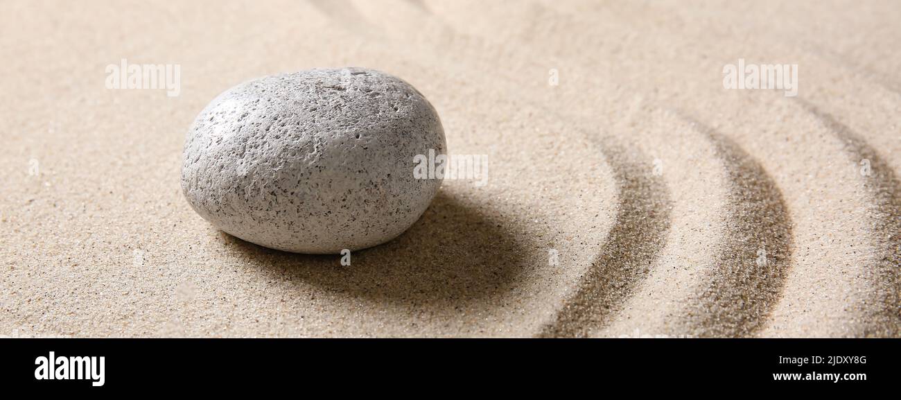 Stone on sand with lines. Zen concept Stock Photo - Alamy