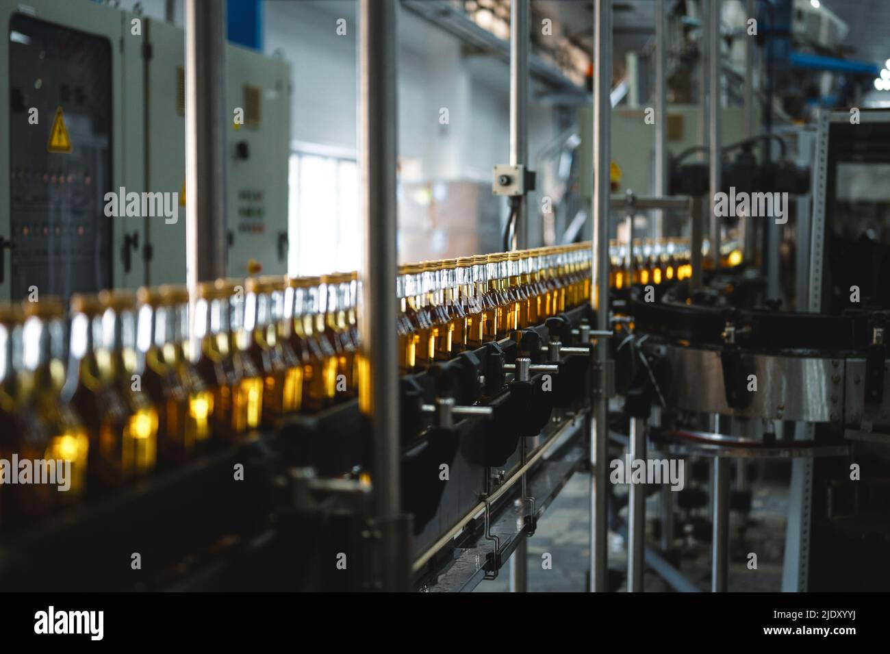 Production line transports closed bottles of yellow alcohol Stock Photo ...