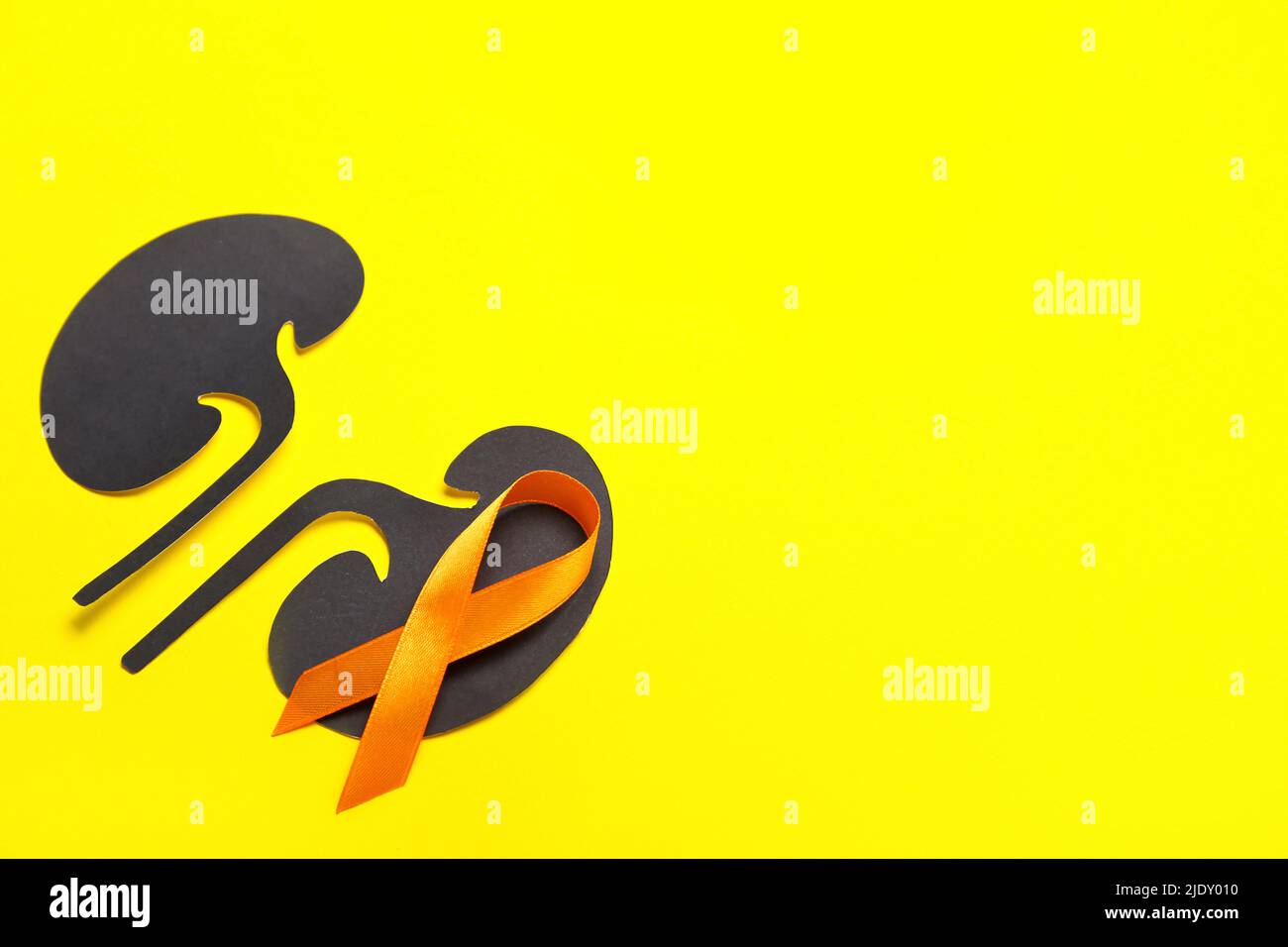 Orange awareness ribbon and paper kidneys on yellow background Stock ...