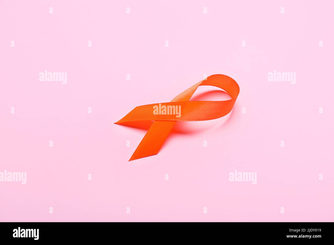Orange awareness ribbon on pink background. Kidney cancer concept Stock ...