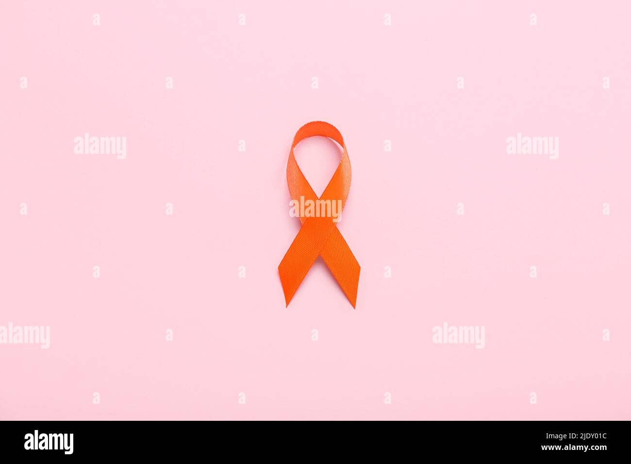 Orange awareness ribbon on pink background. Kidney cancer concept Stock ...
