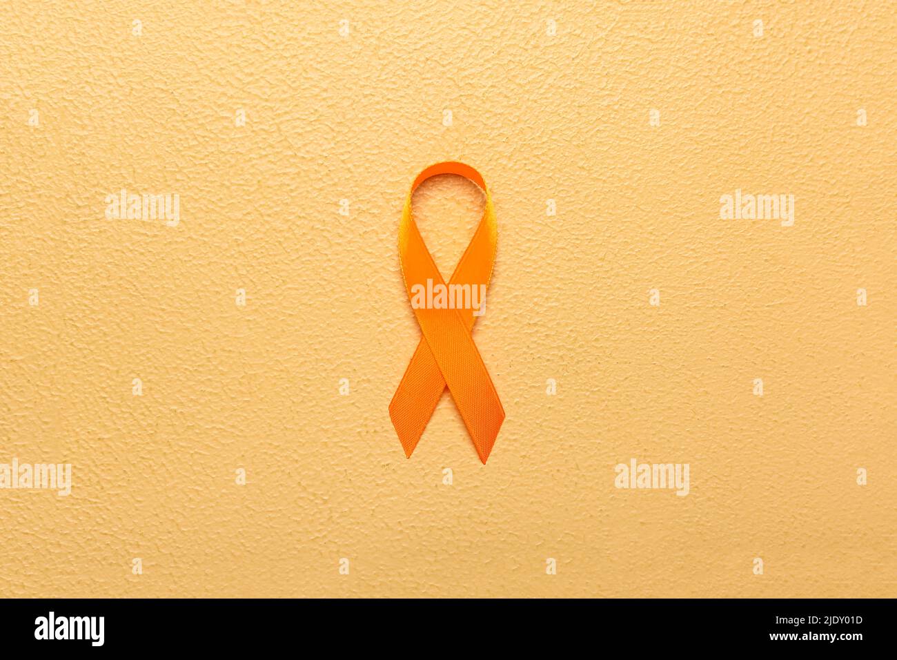 Orange awareness ribbon on beige background. Kidney cancer concept ...