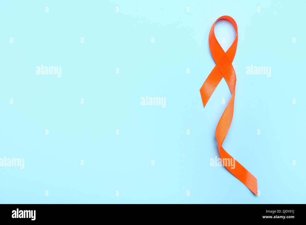 Orange awareness ribbon on blue background. Kidney cancer concept Stock ...