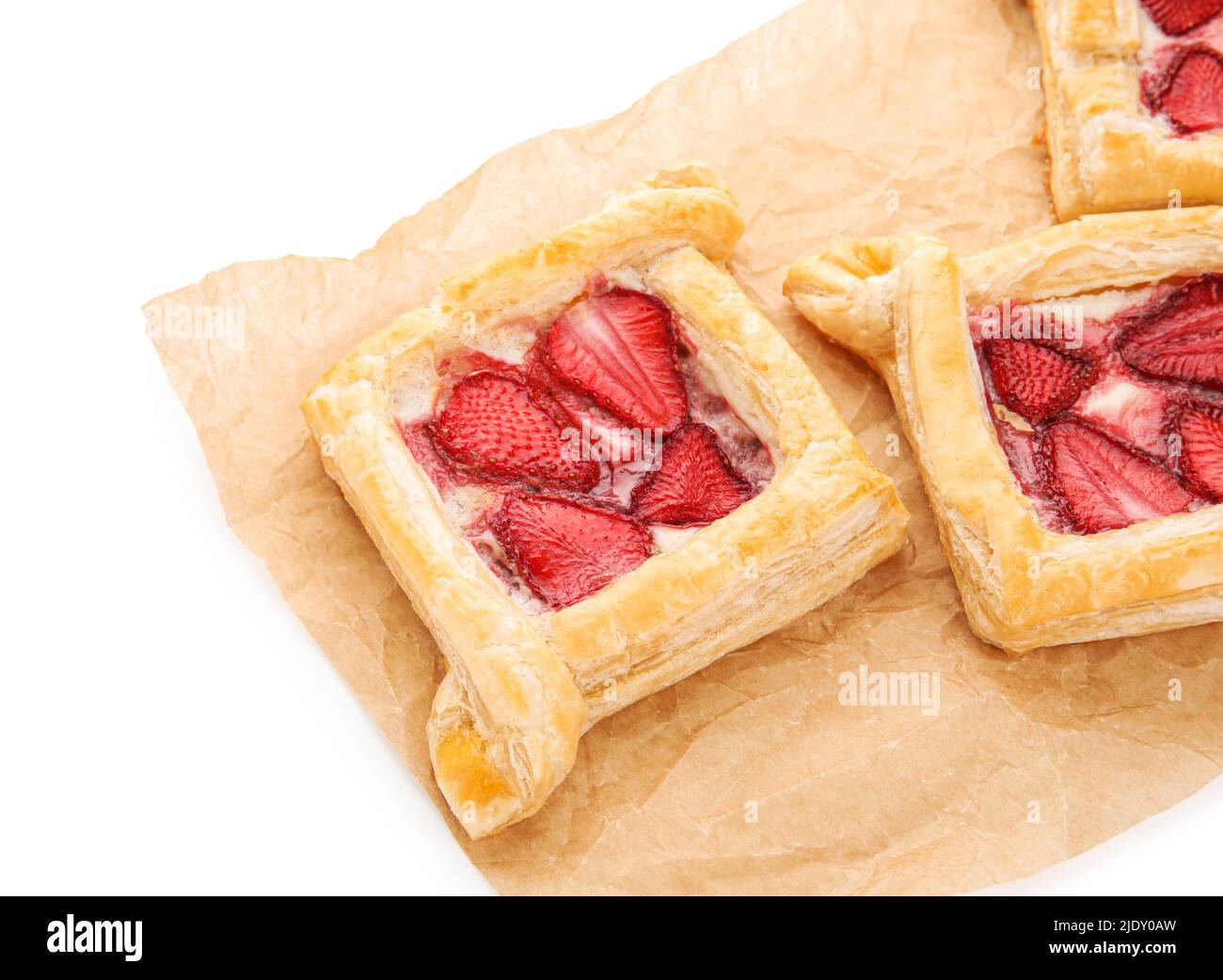 Parchment paper with strawberry puff pastries on white background Stock ...