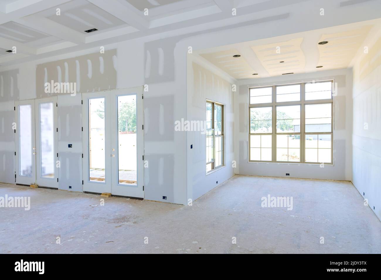 In preparation for painting a newly house, finishing putty is being ...