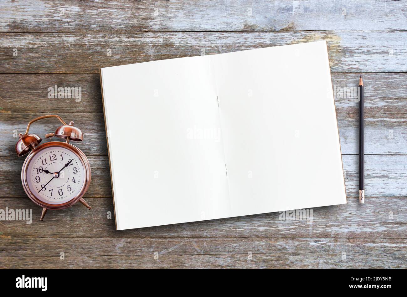 Vintage alarm clock,pencil and notepad on wood table background ...