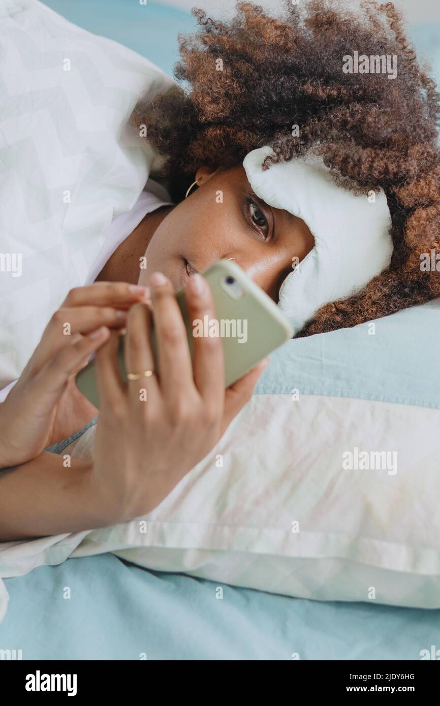 woman in bed with phone Stock Photo - Alamy