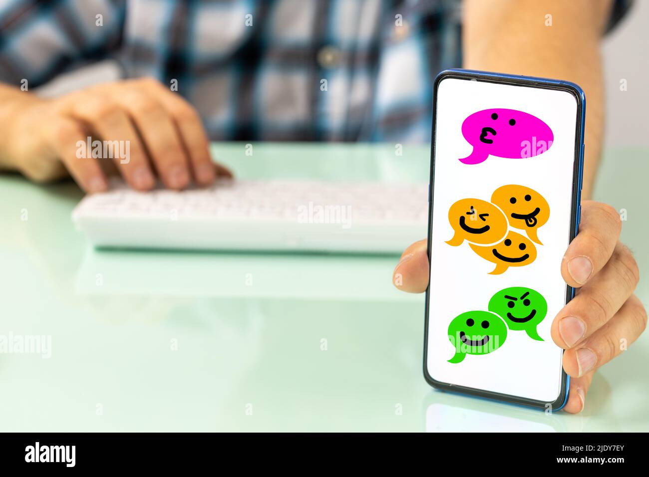 The man behind the desk shows the phone with comic speech bubbles of ...