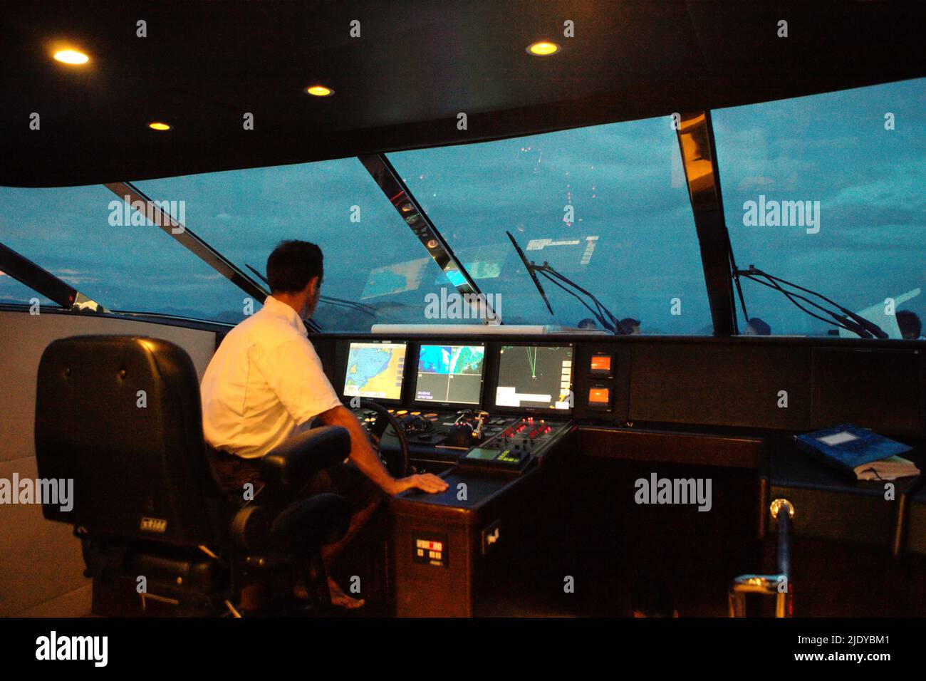 Helmsman paying attention to navigation systems as he is steering a ...