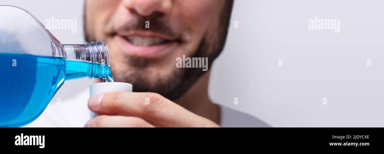 Close-up Of A Man's Hand Pouring Mouthwash Into Cap Stock Photo - Alamy