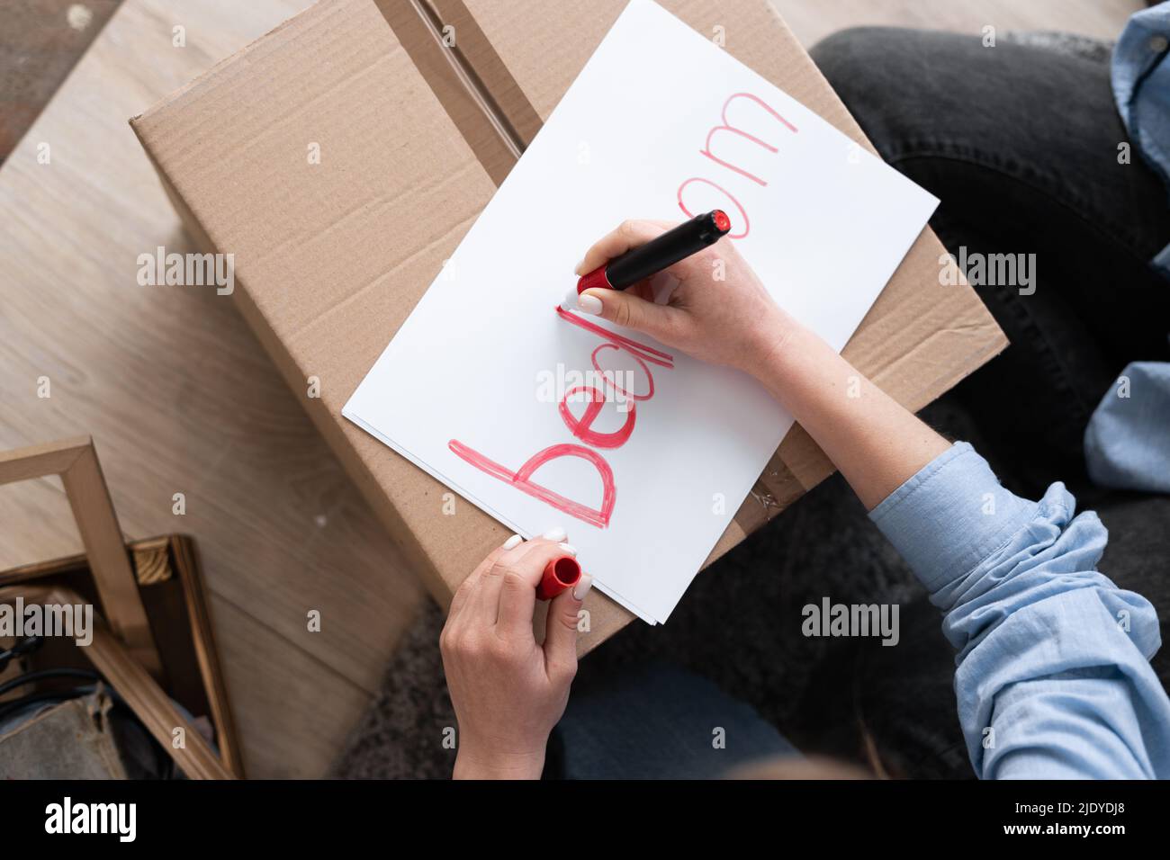 preparing boxes for moving, top view of hand signing big box, moving ...