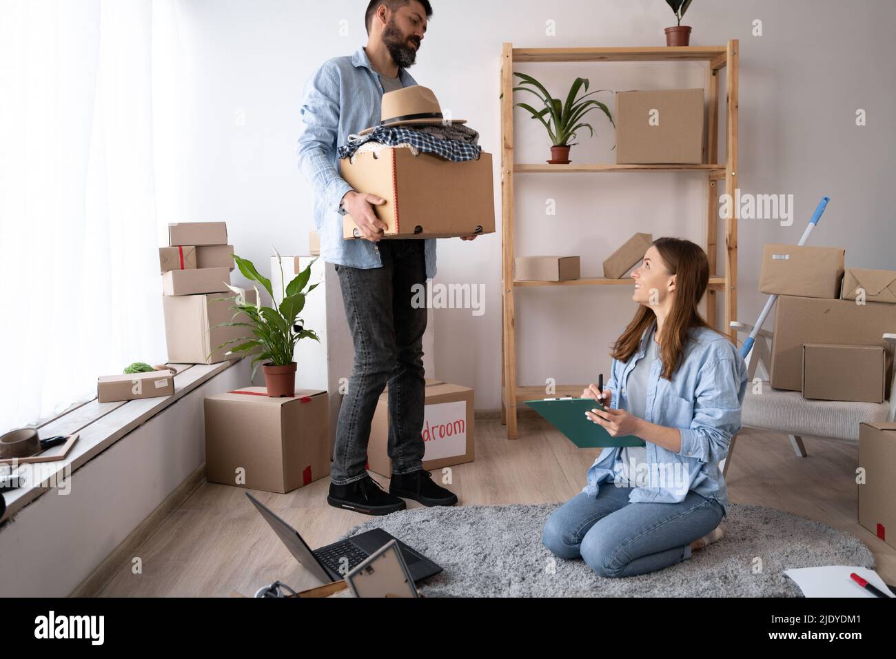 Young couple packing and checking stuff by using checklist before ...