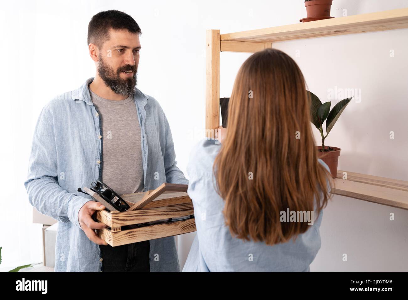 college couple in love packing things in wood boxes carrying them out ...