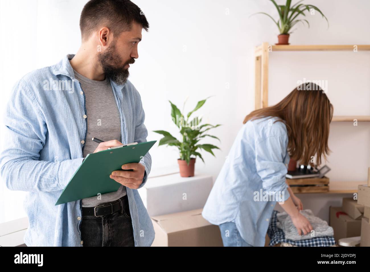 Happy man checking stuff in cardboard box before sent to transportation ...