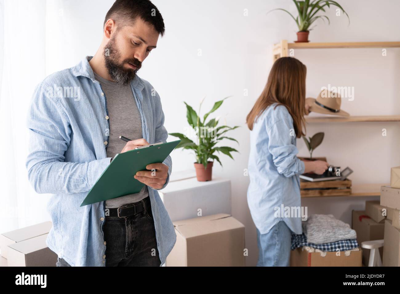 Happy man checking stuff in cardboard box before sent to transportation ...
