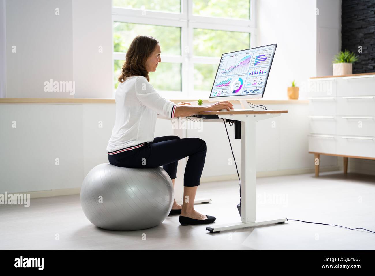 Correct Posture At Desk In Office Using Fitness Ball Stock Photo - Alamy