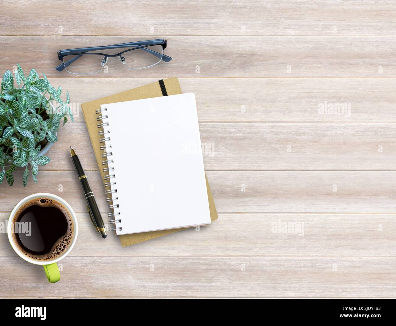 Top view blank notebook,glasses,pen,cup of coffee on wood table ...