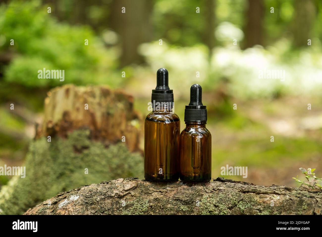 Two glass brown cosmetic containers with pipette are placed against ...