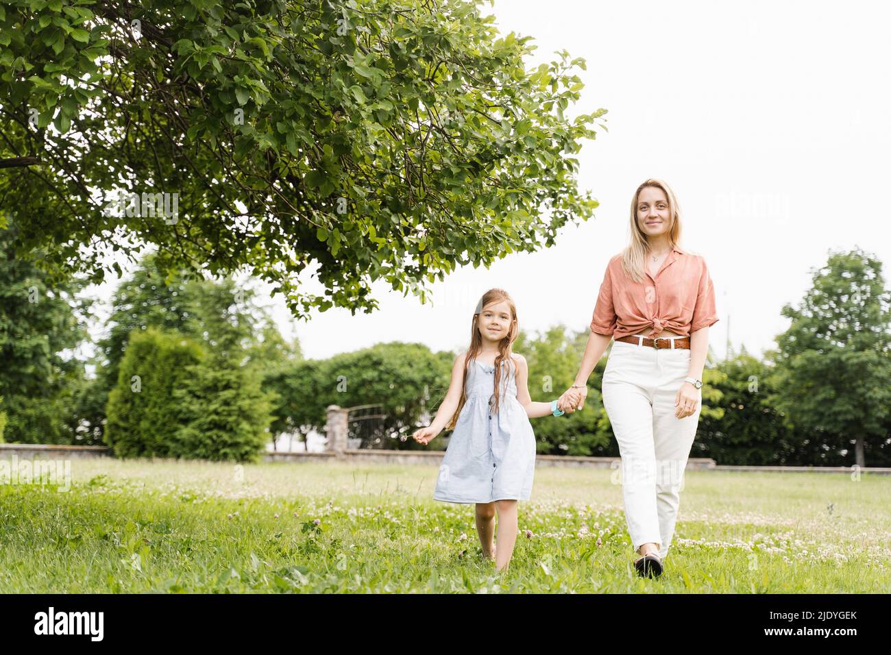 Mom and daughter walking and having fun together in the park. Happy family lifestyle. Love in ...