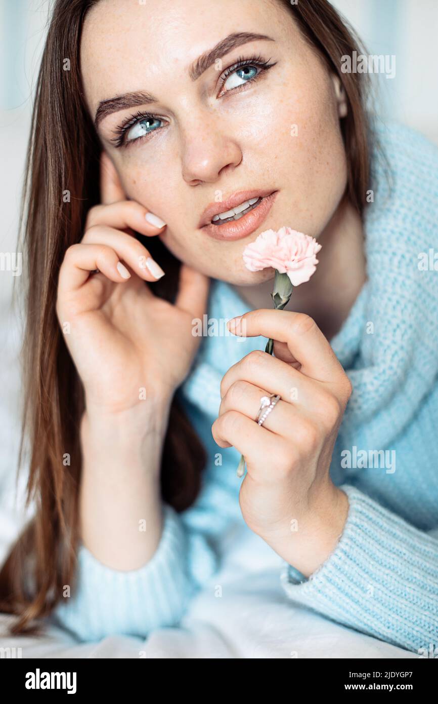 Cute Young Woman Holding Delicate Flower In Hand Near Face Closeup