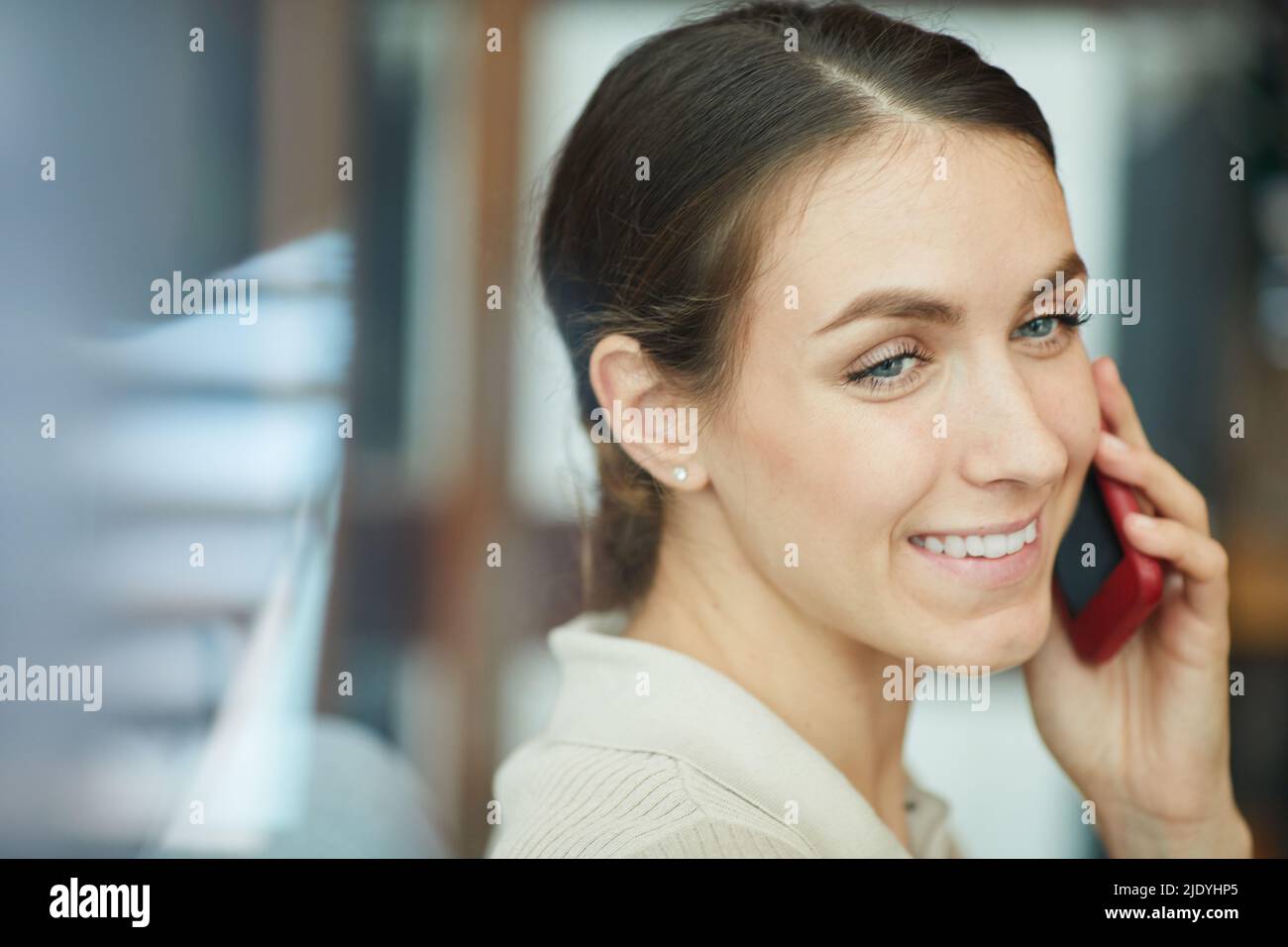 Smiling friendly young secretary with brown hair talking to customer by ...