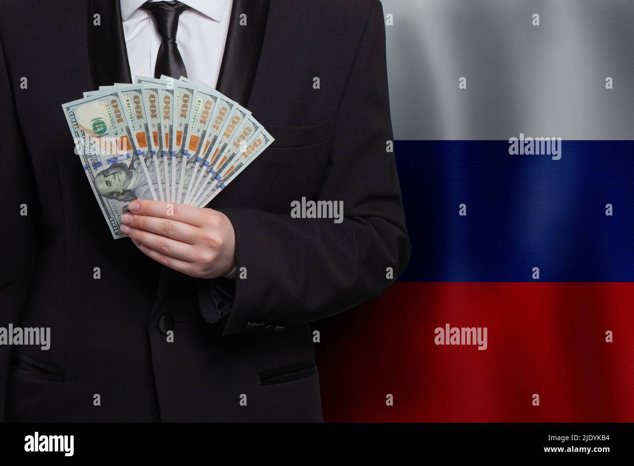 Business man with 100 US dollar bills money banknotes against flag of ...