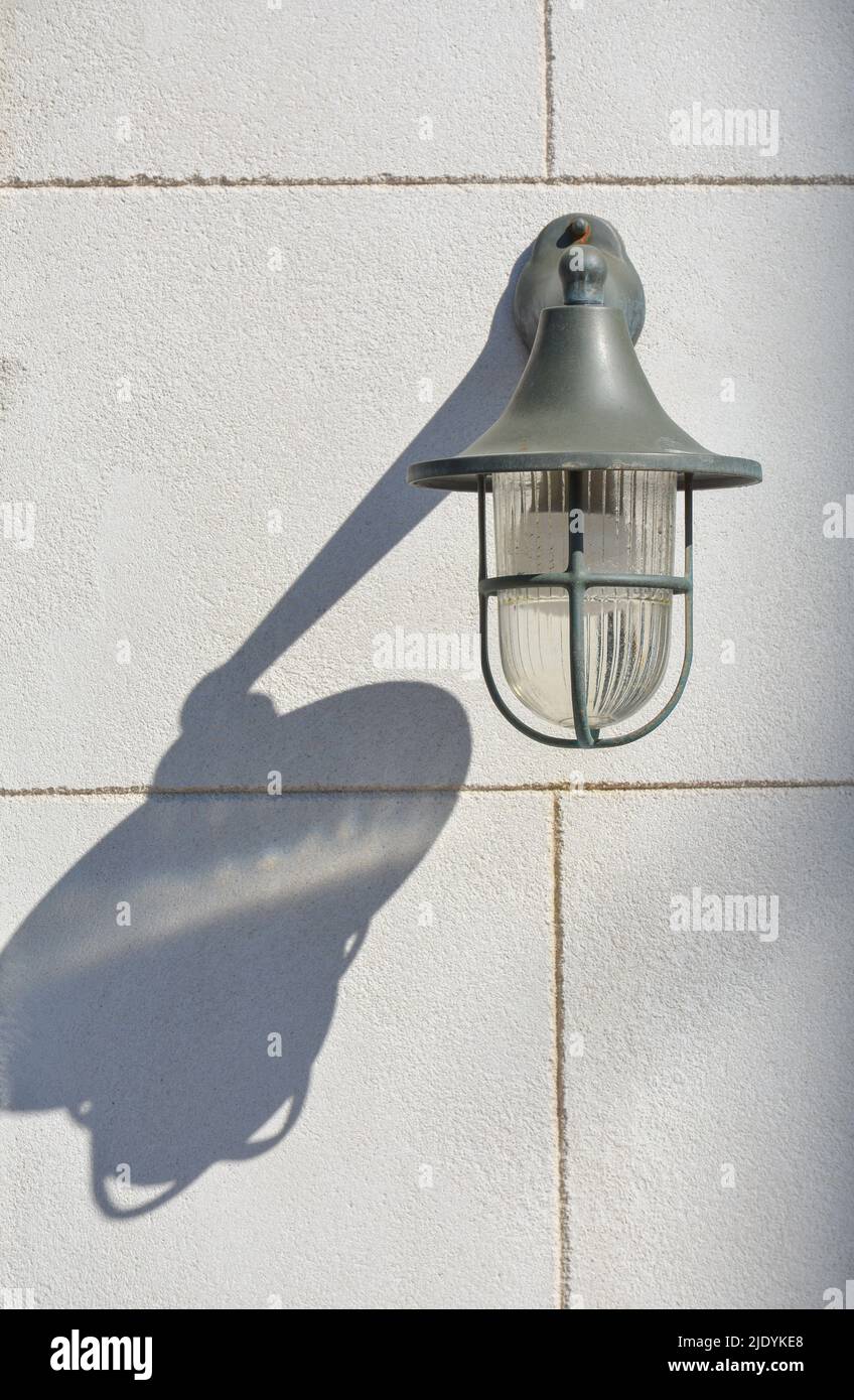 Abstract image with a wall mounted lamp casting a shadow on the ...