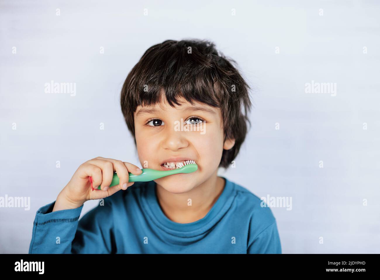 Little boy brushing his teeth on white background. little kid cleans ...