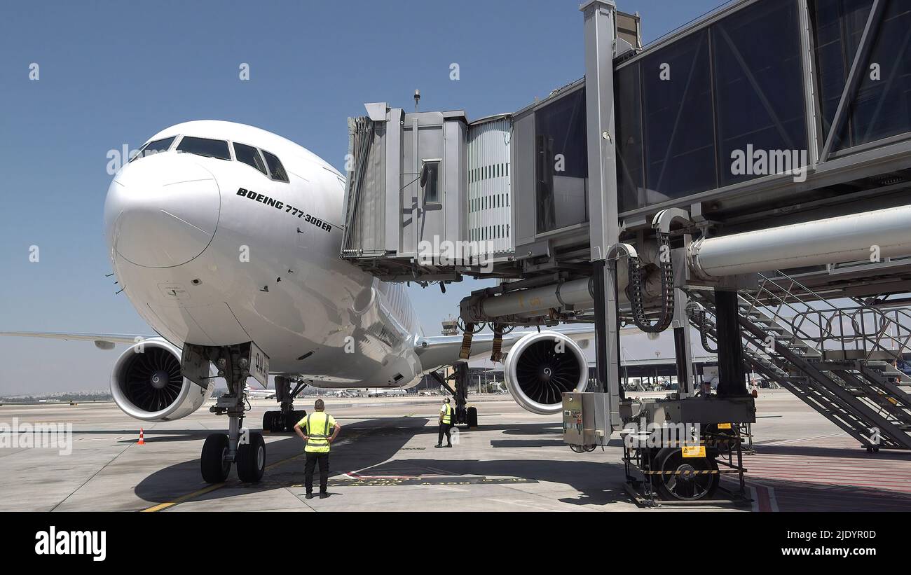 A jet bridge walkway approaches a Boeing 777-300ER aircraft soon after ...