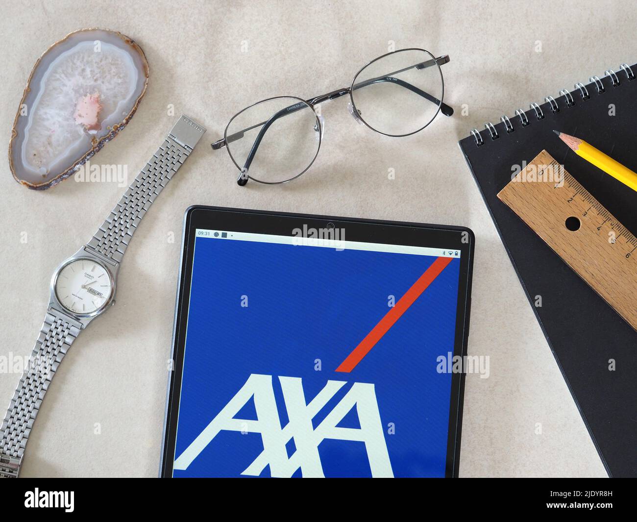 In this photo illustration AXA Group logo seen displayed on a tablet ...