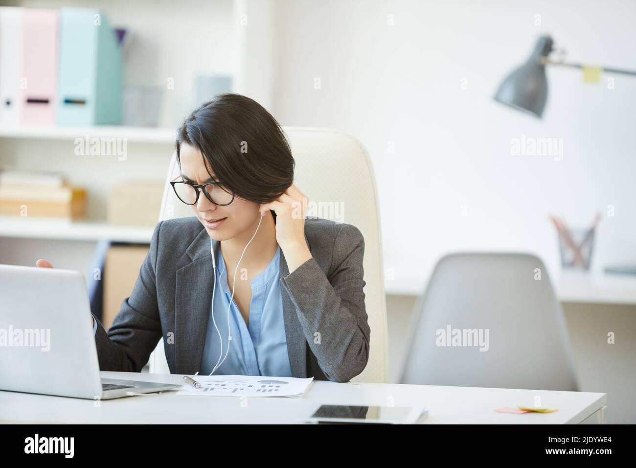 Displeased frowning female project manager in forma outfit sitting at ...