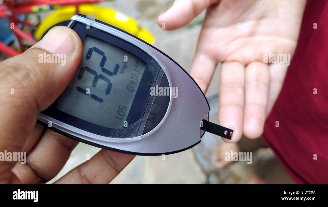 Diabetes machine in hand prick finger to make punctures to obtain small ...