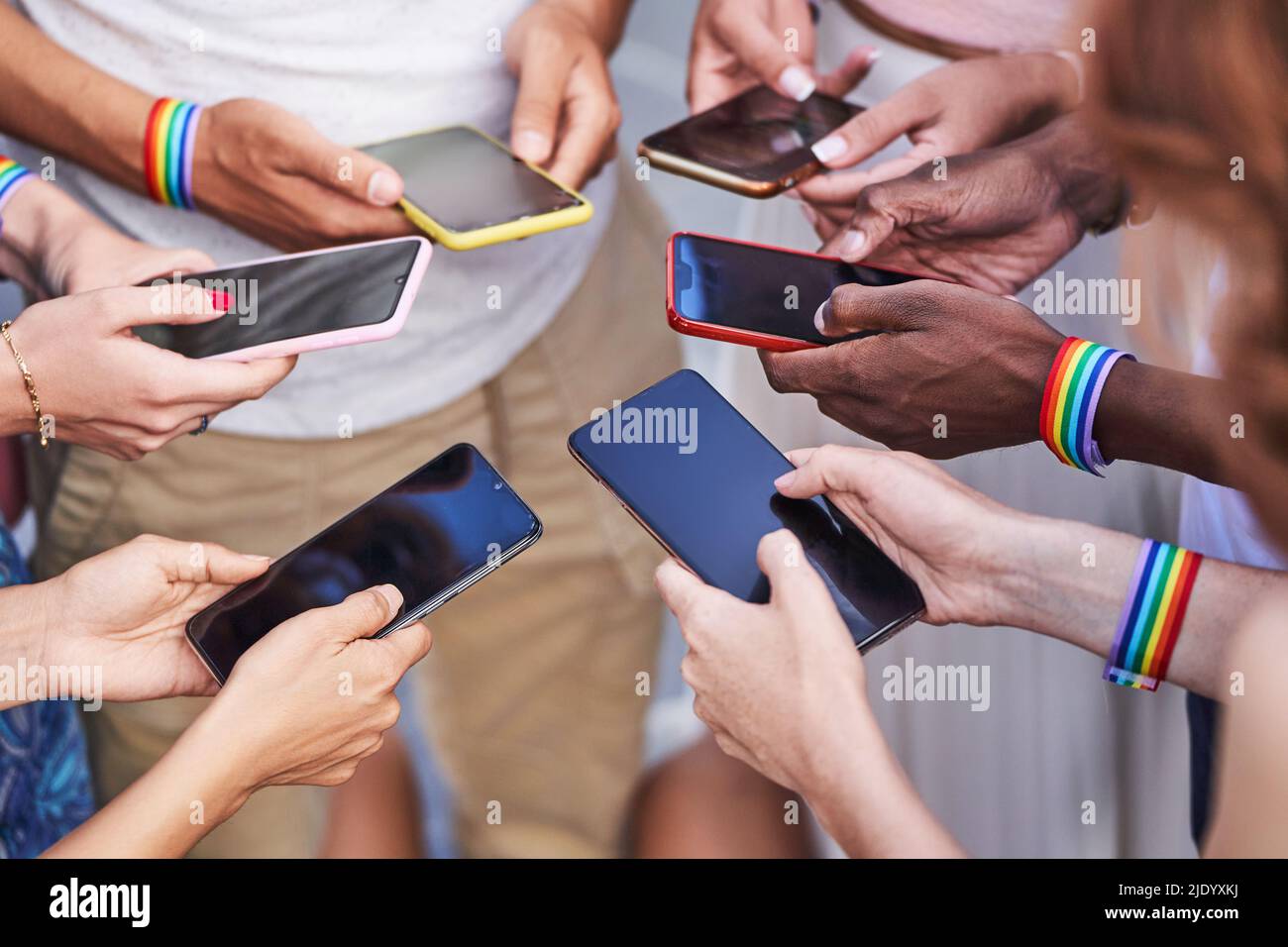 Group of multiracial people with LGBT rainbow flag wristbands using ...