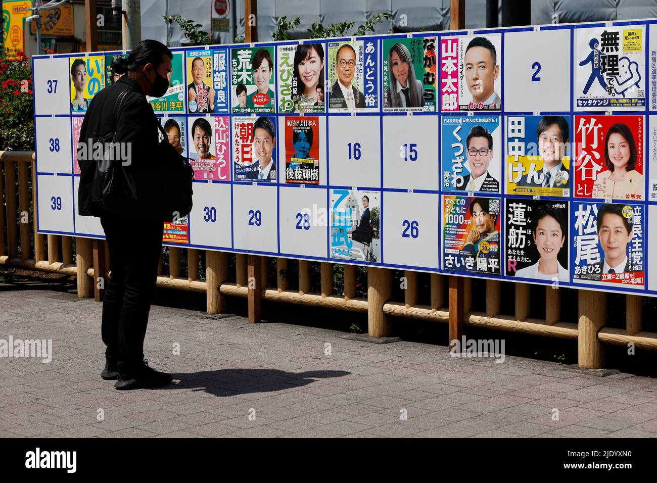 Tokyo, Japan. 24th June, 2022. A man looks at candidates' posters for ...