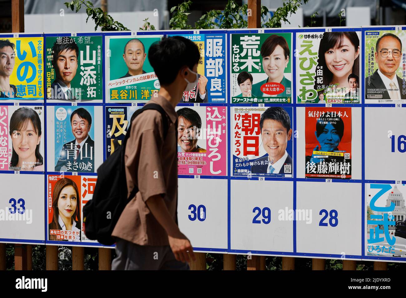 Tokyo, Japan. 24th June, 2022. A man looks at candidates' posters for ...