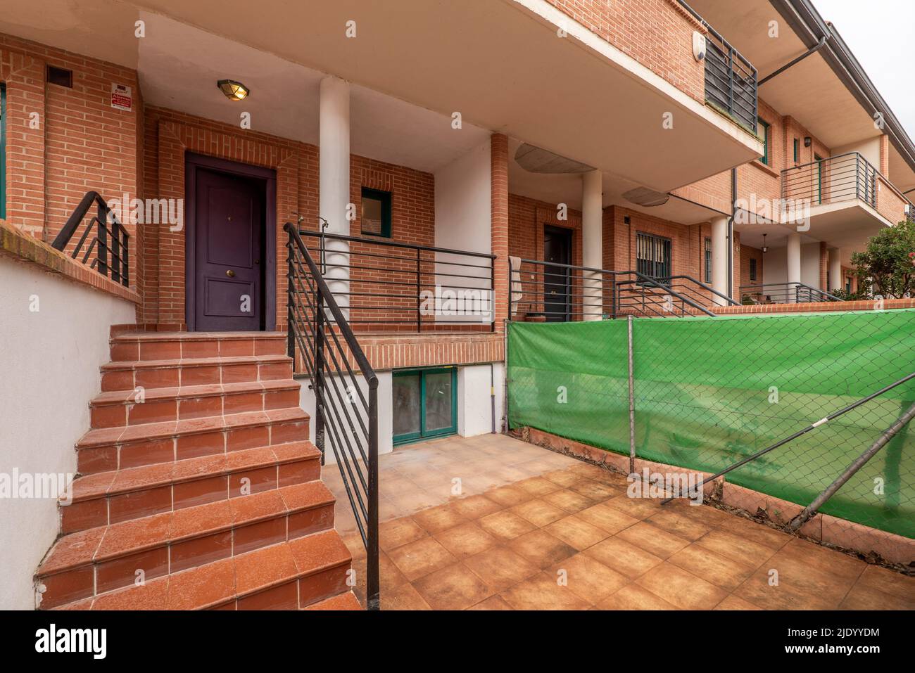 Patio of a single-family home with a clay staircase and a brown access ...