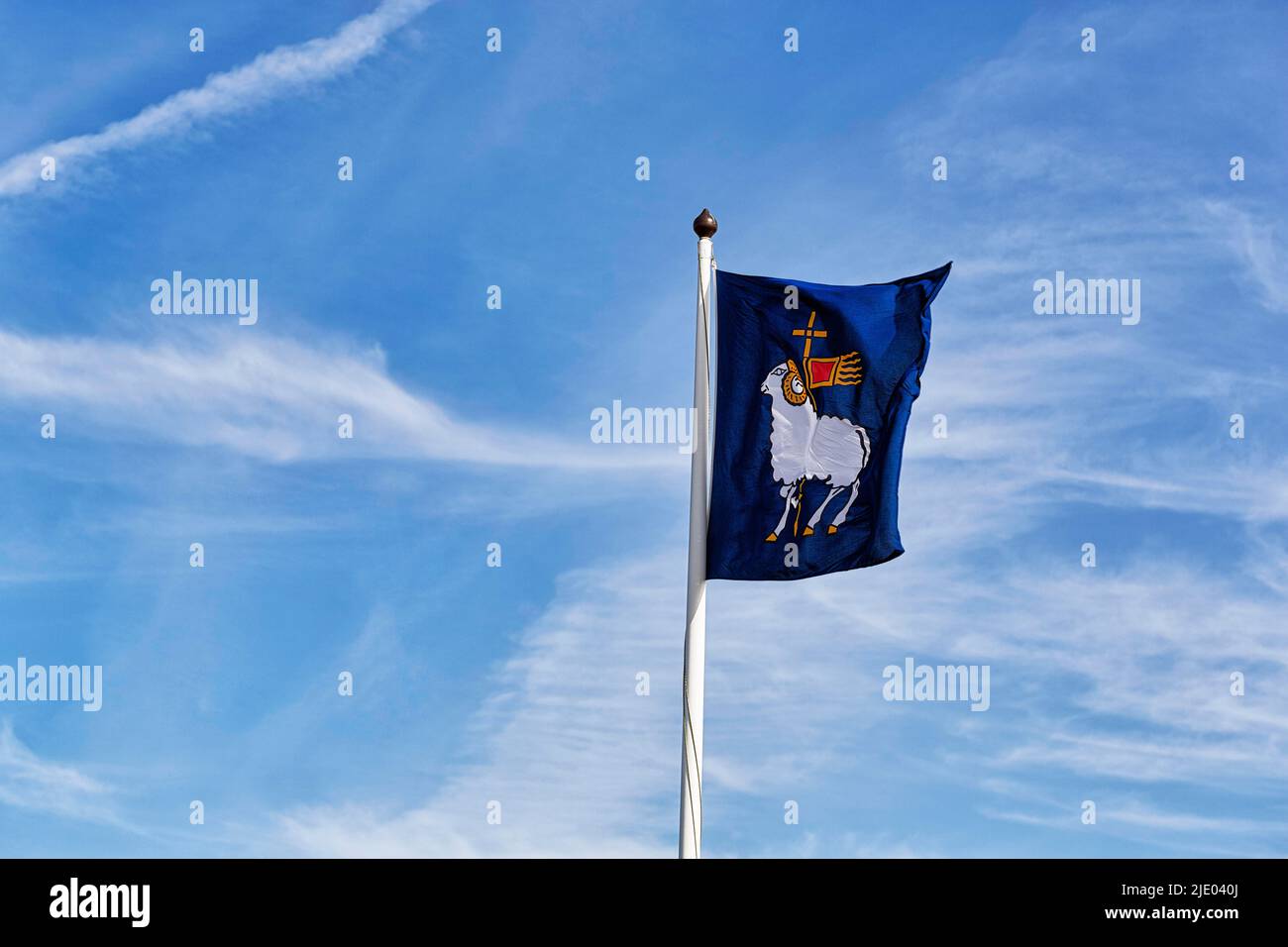 Official flag of Gotland against a slightly cloudy sky, coat of arms of ...