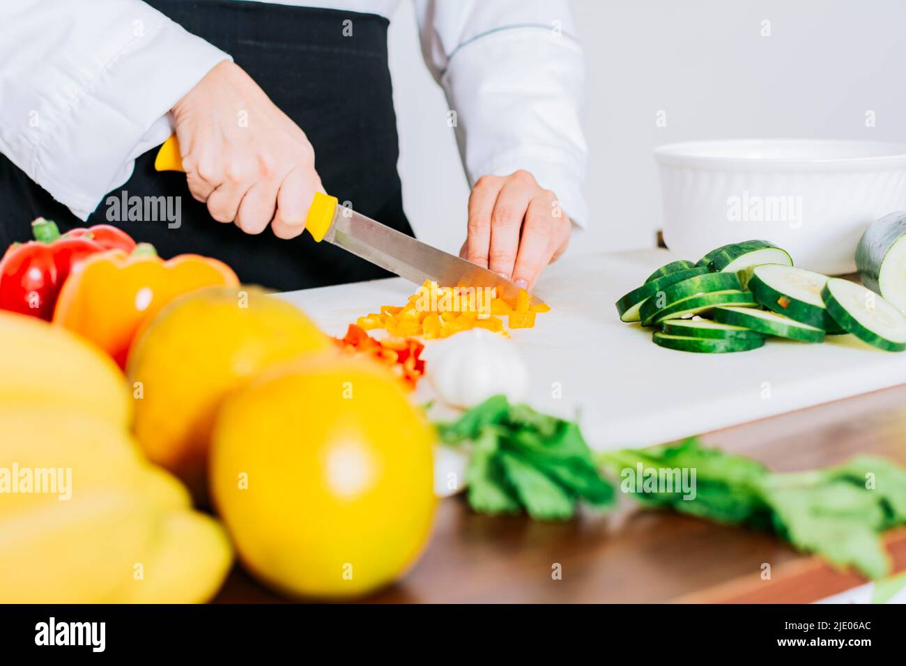 Close up of a female chef cutting vegetables, Hands of female chef ...