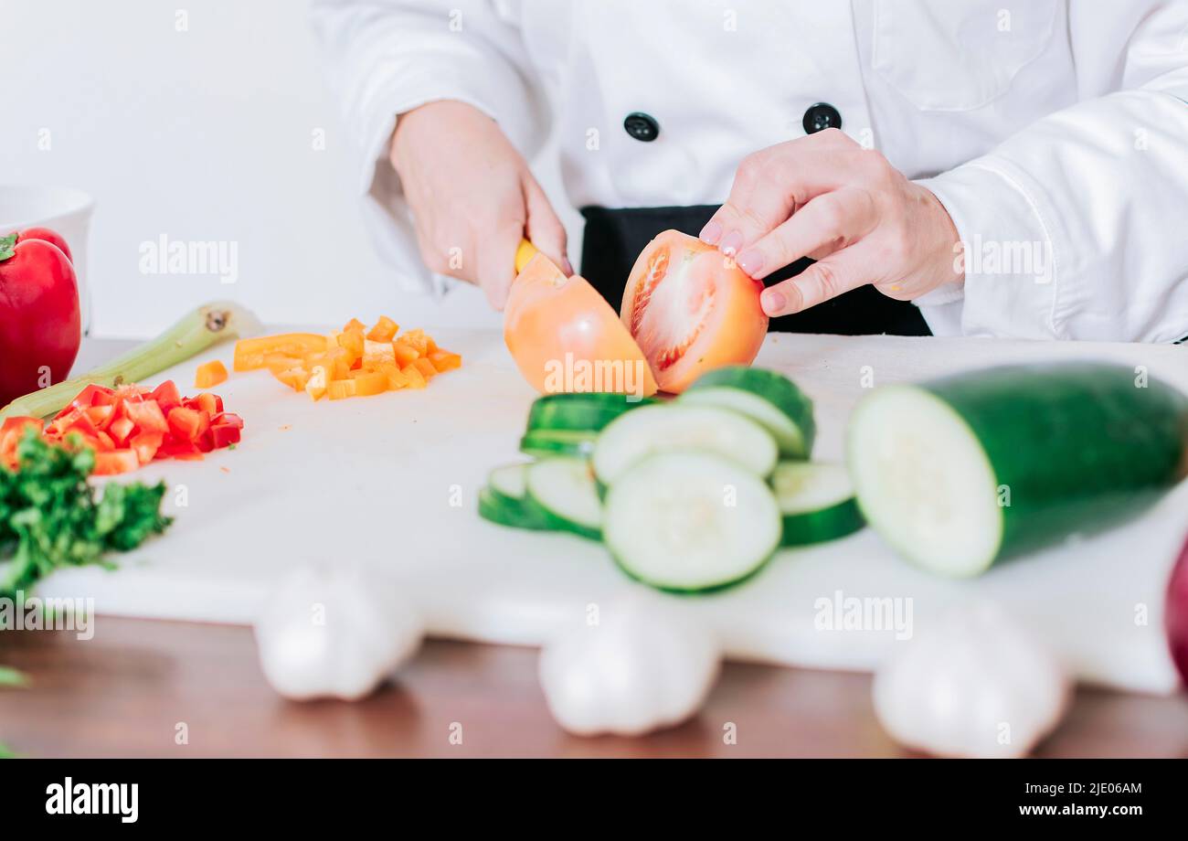 Close up of chef woman hands cutting tomatoes and vegetables, chef ...