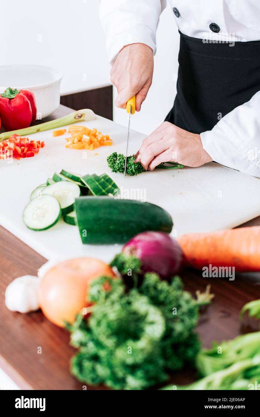 Hands of female chef cutting vegetables, chef hands preparing and ...