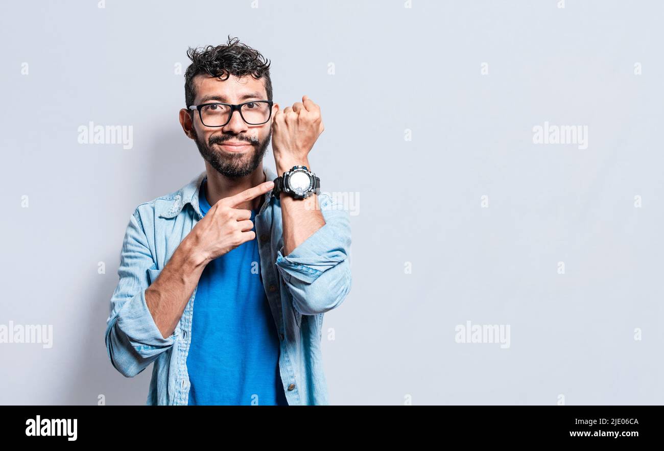 Person pointing at his watch looking at the camera. Friendly man ...