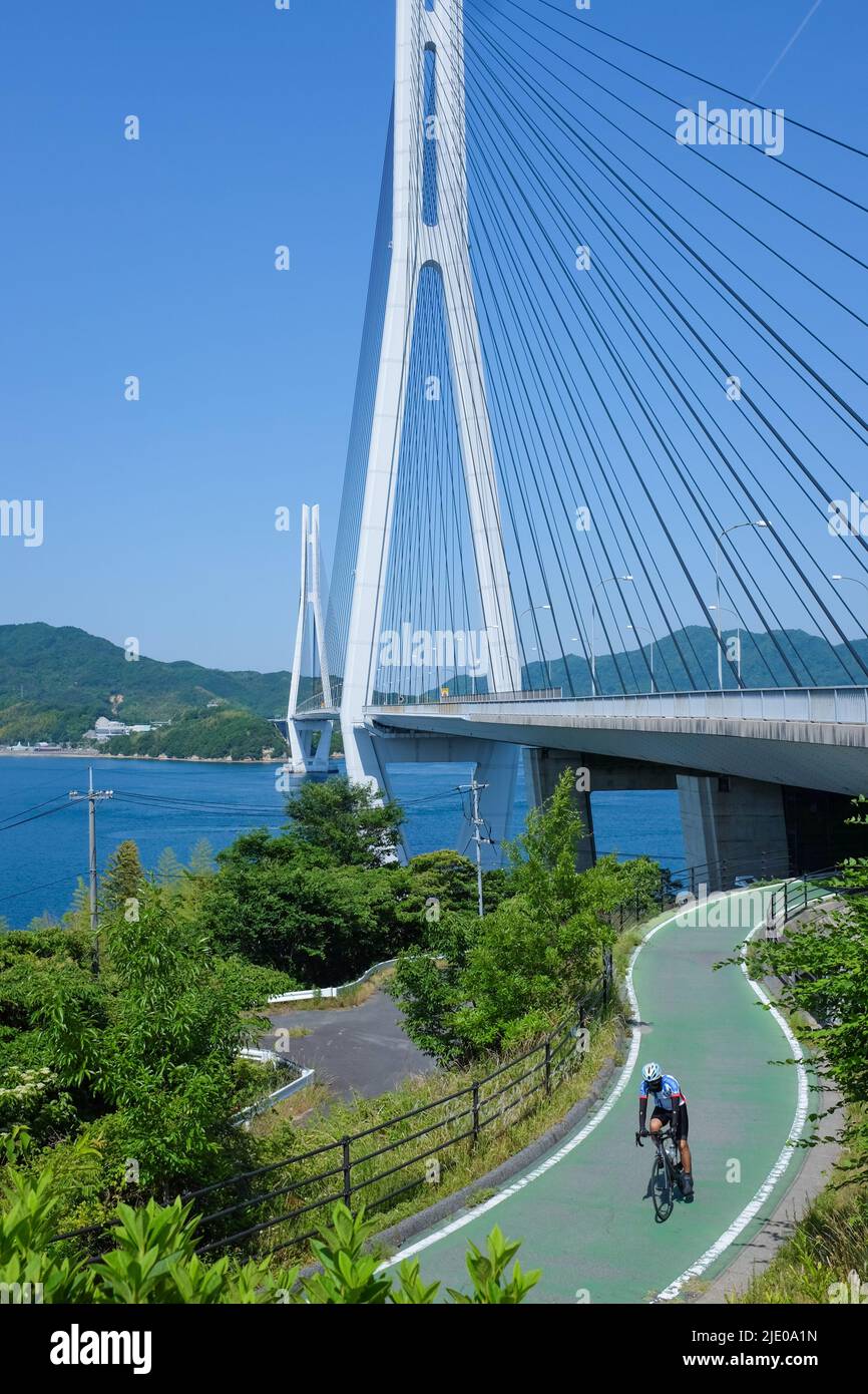 Cyclists riding along the Shimanami Kaido bike route between Onomichi ...