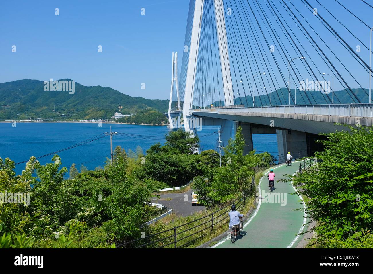 Cyclists riding along the Shimanami Kaido bike route between Onomichi ...