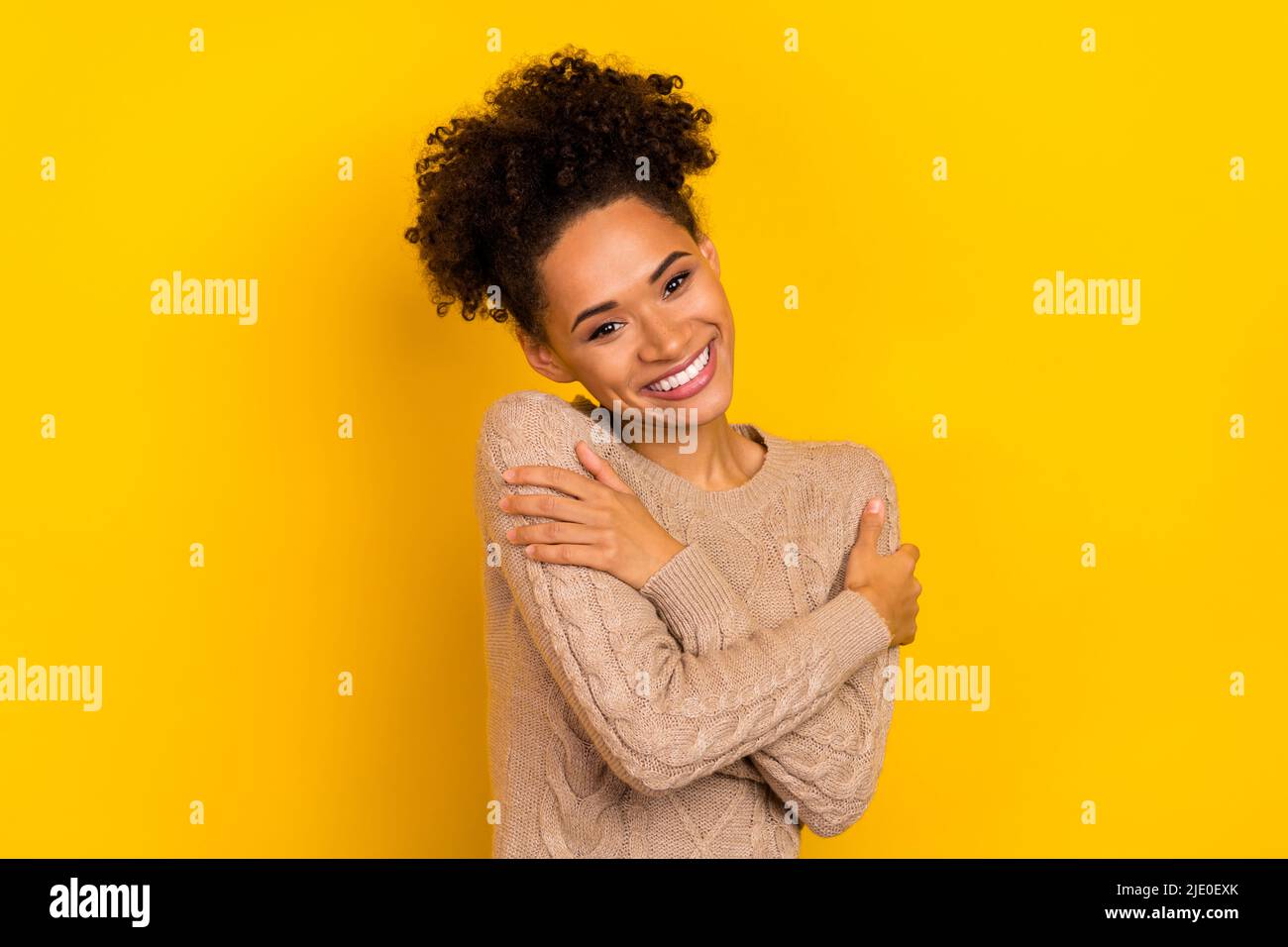 Photo of dreamy adorable woman wear beige sweater hugging herself ...